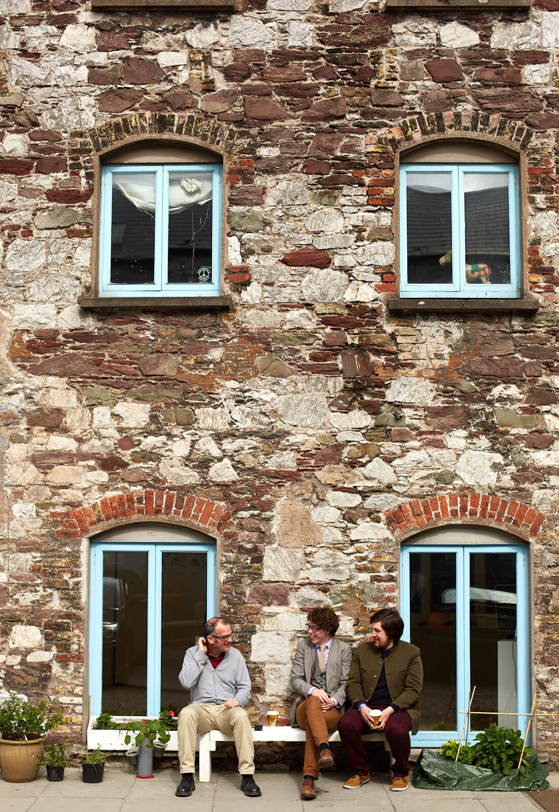 Three friends sit outside old brick building in Ireland | The Morrisons ...